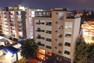 Um hotel de vários andares com design arquitetônico moderno, com varandas e grandes janelas.
