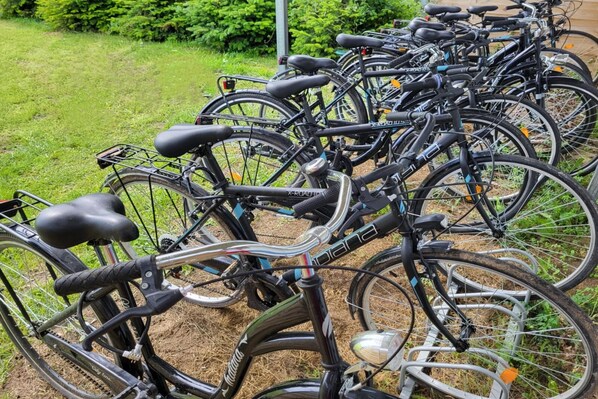 Várias bicicletas estacionadas ao ar livre, possivelmente em um espaço público ou compartilhado.