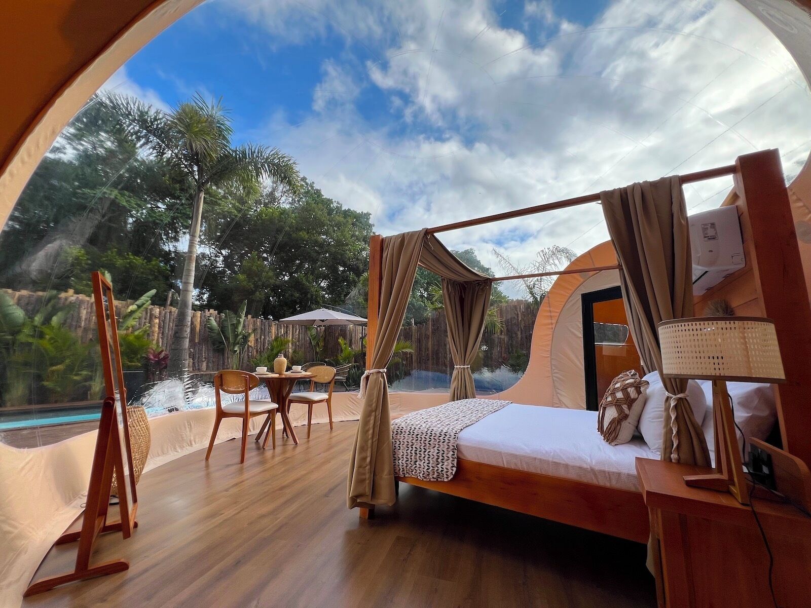 Quarto espaçoso com uma cama grande, área de refeições e vista para o exterior.
