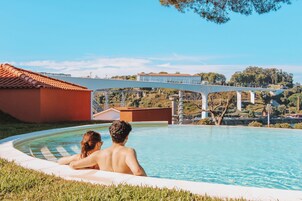 Piscina com vista para uma ponte e edifícios ao fundo.