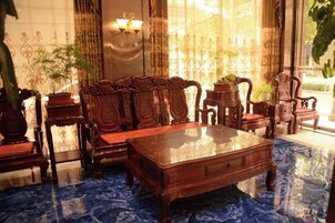 Um quarto com mesa de centro de madeira, cadeiras combinando e piso estampado.