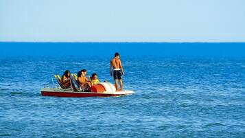 Um barco pequeno com pessoas flutuando na água.