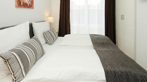 Quarto de hotel com cama, sofá, televisão e um quadro na parede.