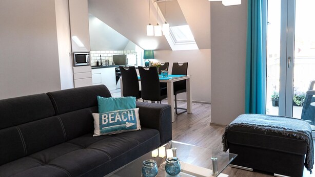 Um apartamento moderno com sala de estar, área de jantar e cozinha.