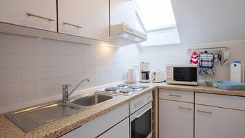 Apartamento | Cozinha privada | Uma chaleira elétrica, uma torradeira, uma cadeira de bebé