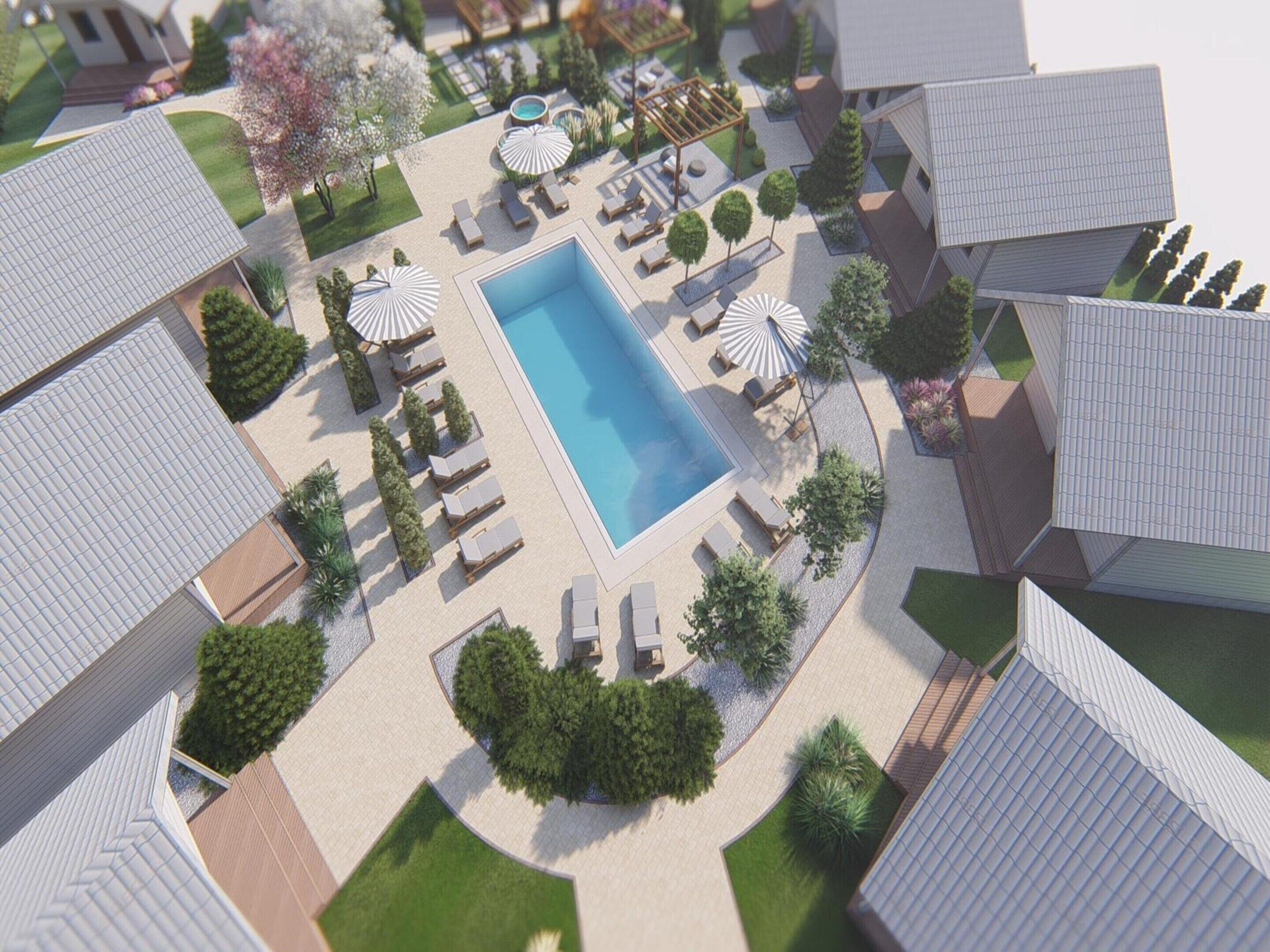 Área de piscina com espreguiçadeiras e guarda-sóis, cercada por vegetação e edifícios.