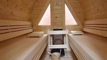 Uma sauna de madeira com bancos e um aquecedor central.