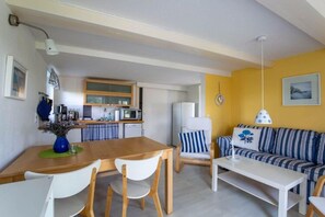 Um espaço compacto com área de jantar, sofá e cozinha compacta.