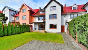 Uma fileira de casas modernas com telhados vermelhos, um caminho de entrada pavimentado e um gramado bem cuidado.