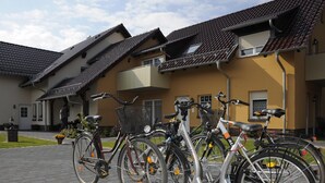 Um edifício com telhado de telhas e suporte para bicicletas na frente.