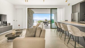 Cozinha moderna com uma ilha grande, banquetas e vista para o exterior.