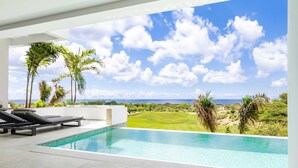 Uma piscina infinita moderna com vista desimpedida para o oceano e paisagem exuberante.