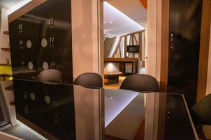 Um interior moderno com um armário de tons escuros, espelhos circulares e superfície refletora.
