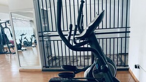 Uma academia com bicicletas ergométricas e elípticos.