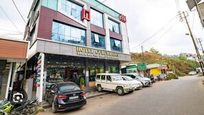Um edifício de vários andares com uma placa indicando Hotel Gurubhan, um restaurante familiar vegetariano e não vegetariano.