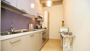 Uma cozinha com uma pia de aço inoxidável, forno embutido e bancada de madeira.