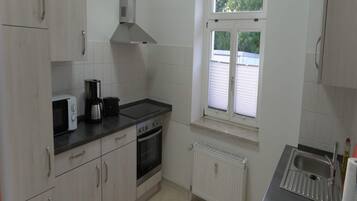 Apartamento | Cozinha privada | Uma chaleira elétrica, uma torradeira, uma cadeira de bebé