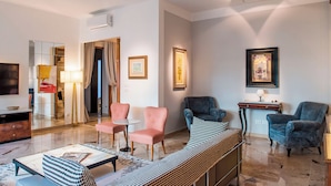 Uma sala de estar moderna com um sofá, duas poltronas, uma mesa de centro e uma televisão.