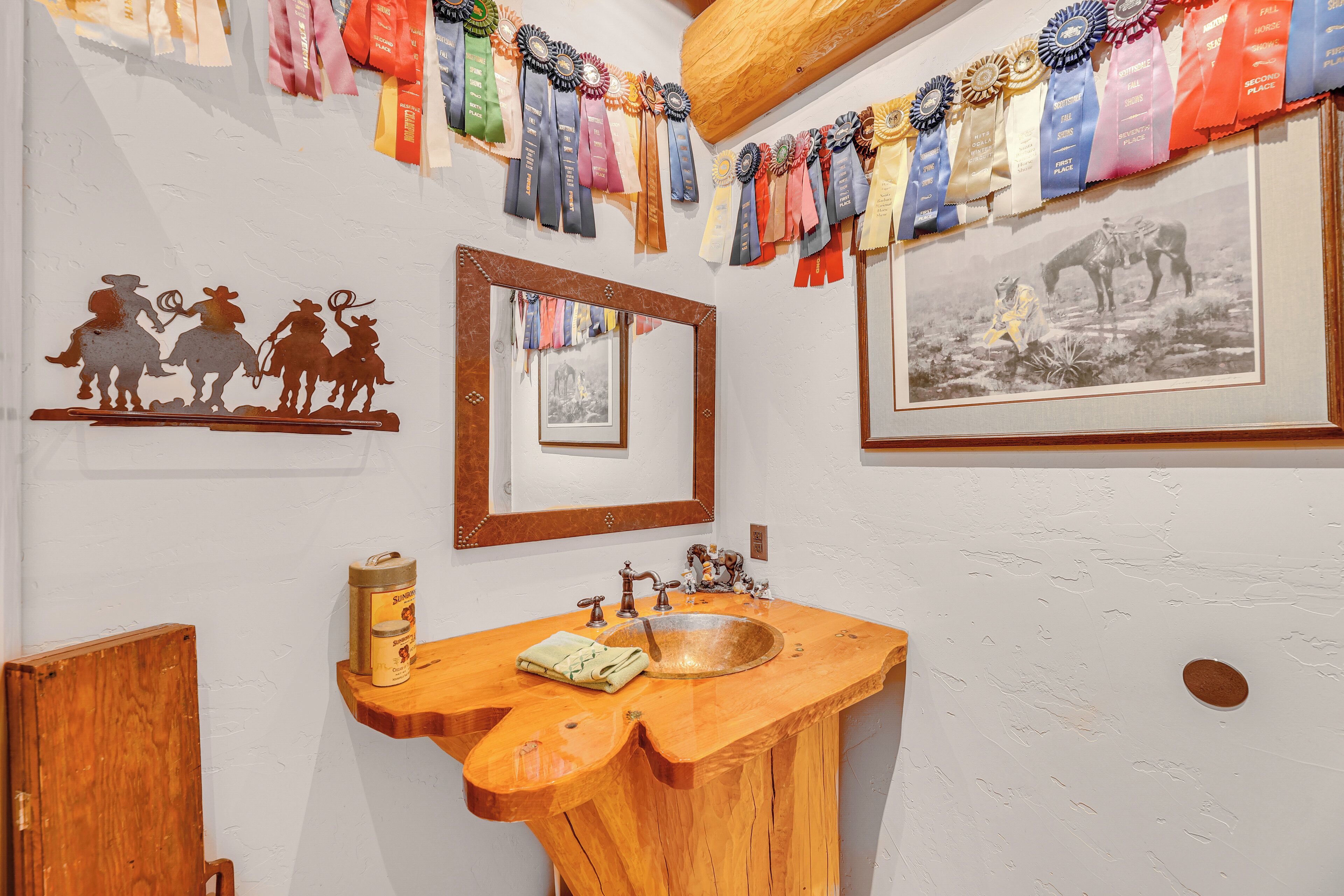 Casa de banho com toucador de madeira, espelho e lavatório.