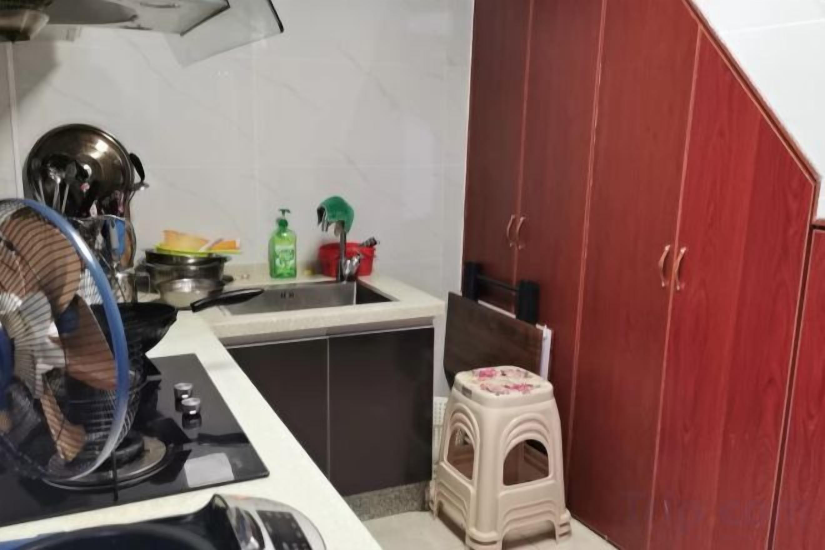 Cozinha compacta com pia, fogão e armários.