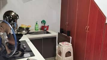 Cozinha compacta com pia, fogão e armários.