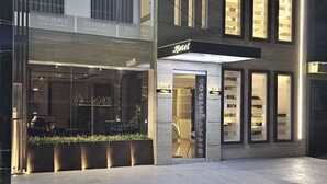 Um hotel com fachada moderna, janelas amplas e entrada visível.