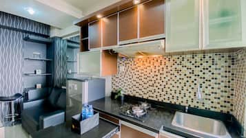 Apartamento | Cozinha privada | Geladeira, cooktop, panela elétrica de arroz, mesas de jantar