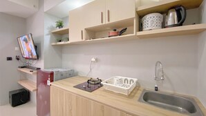 Uma cozinha moderna com armários de madeira, uma pia embutida e bancada com chaleira e cesta.