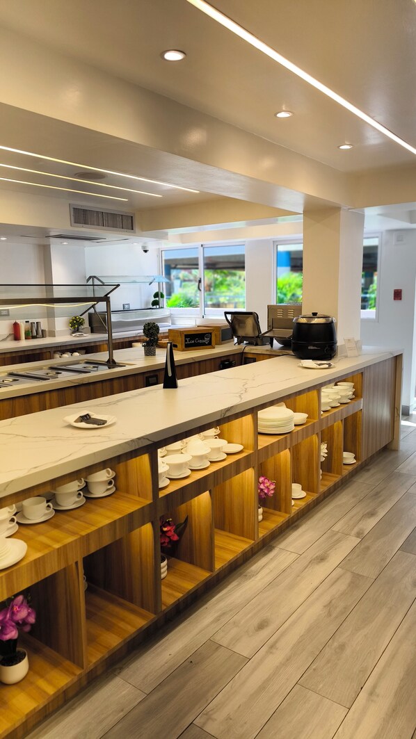 Cozinha moderna com bancada de mármore, prateleiras de madeira e máquina de café.