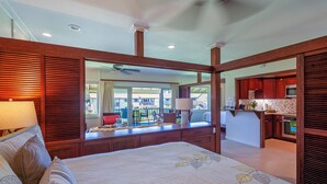 Quarto com cama grande, uma escrivaninha e vista para a varanda.