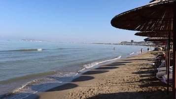 Praia particular, guarda-sóis, toalhas de praia
