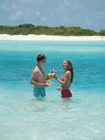 Perto da praia, areia branca, guarda-sóis, toalhas de praia