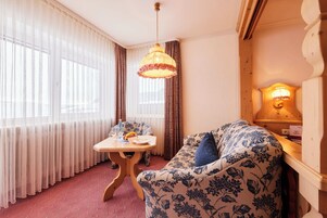 Um quarto aconchegante com um sofá floral, uma mesa de madeira e um abajur.