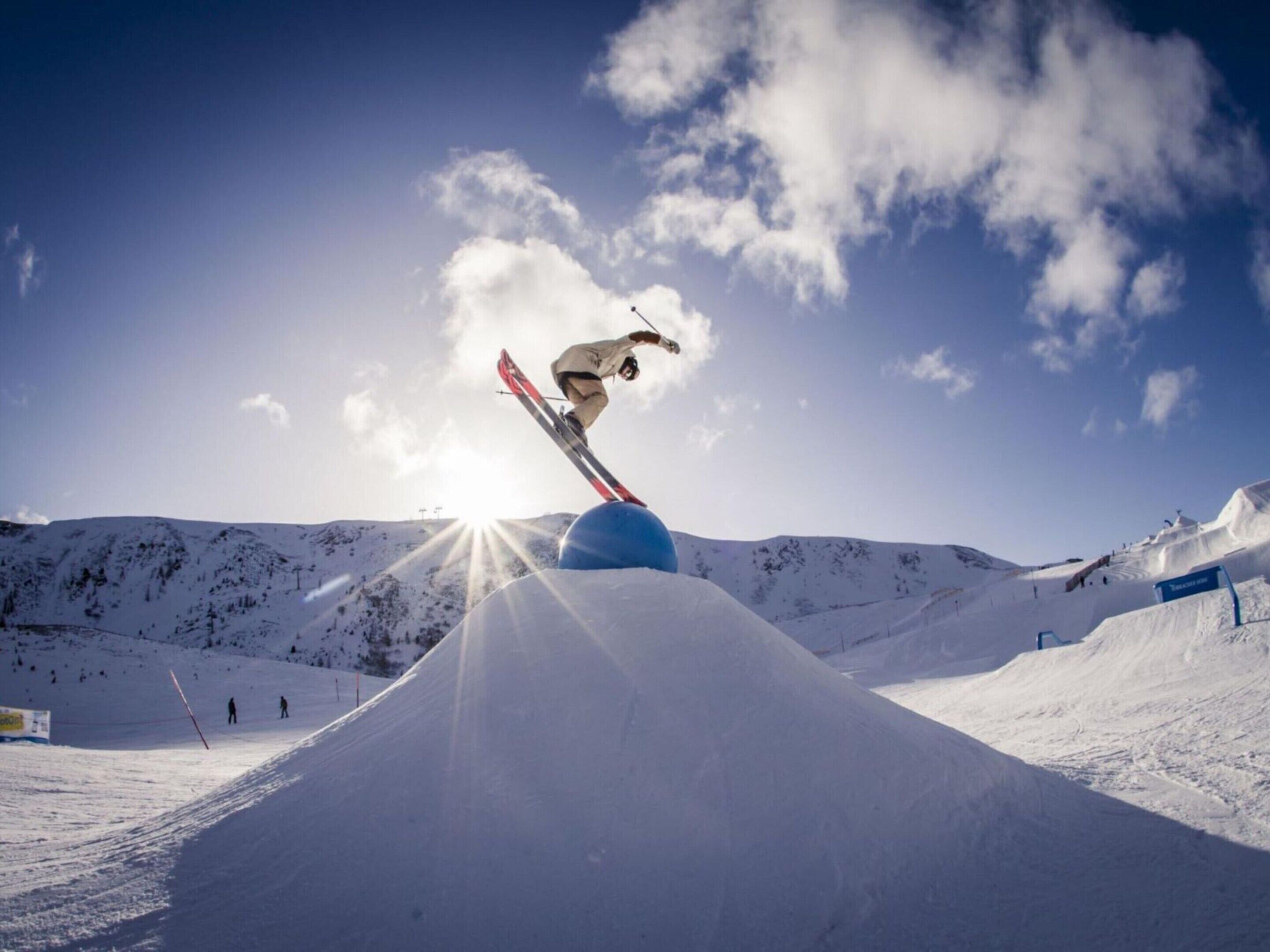 Um esquiador executando um salto sobre uma rampa de neve.