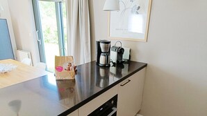 Uma cozinha moderna com uma cafeteira, um pacote de café e uma moldura com uma fotografia no balcão.