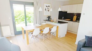 Um apartamento moderno com área de refeições, cozinha e sala de estar.