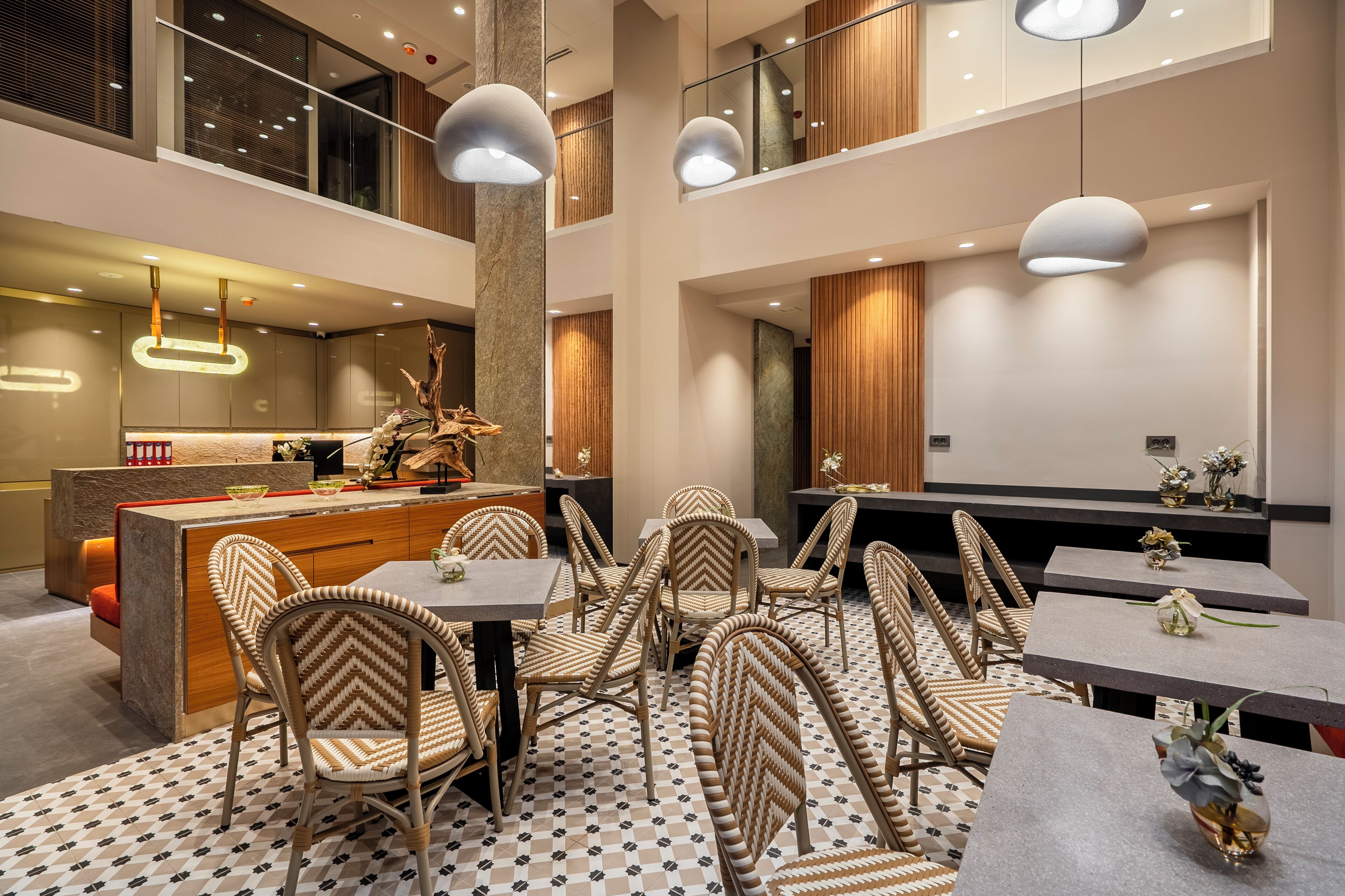 Uma sala de jantar moderna com pé direito alto, iluminação pendente e uma ilha central com assentos.