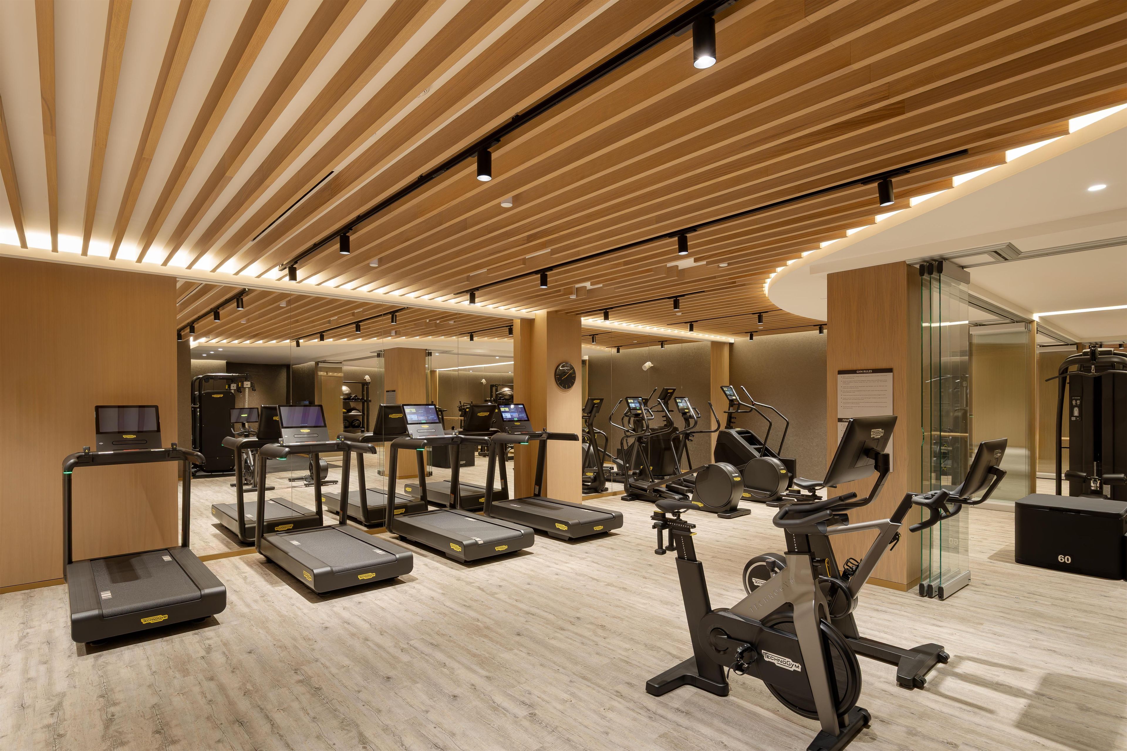 Academia moderna com esteiras, elípticos e bicicletas de exercício.
