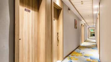 Corredor de hotel com portas de madeira, numeradas 8269, e carpete estampado.