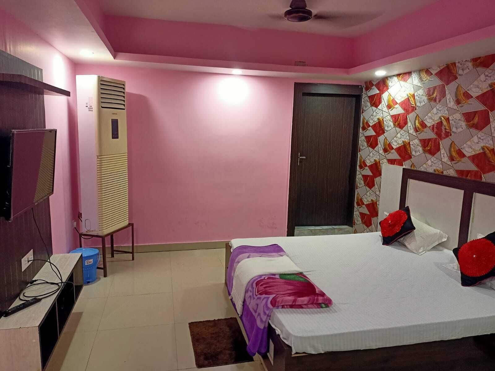 Quarto com cama, televisão, aquecedor e porta.