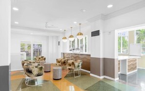Uma área de espera moderna com assentos confortáveis, um espaço para café e vista para o exterior.