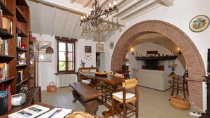 Uma sala de estar aconchegante com lareira, móveis de madeira e uma estante de livros.