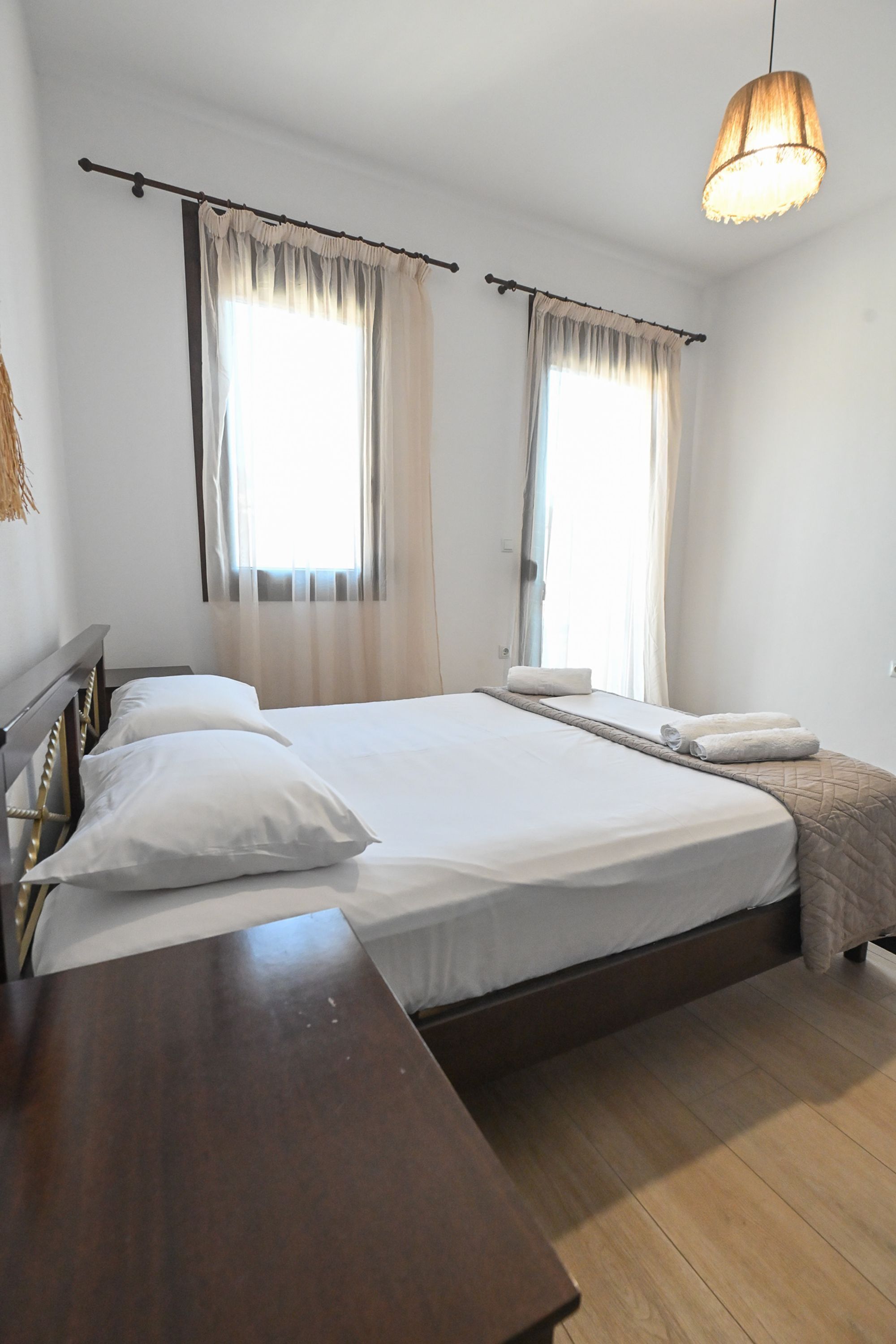 Quarto bem arrumado com uma cama, mesas de cabeceira e um candeeiro suspenso.