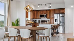 Uma cozinha moderna com armários de madeira, eletrodomésticos de aço inoxidável e uma ilha central com bancada.