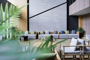 Uma área de estar moderna com sofás, móveis de madeira e plantas em vasos.