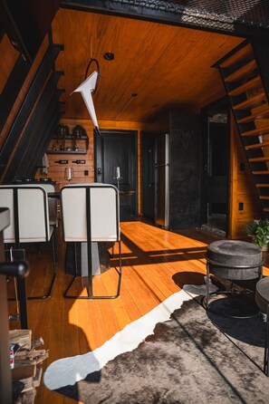Uma cozinha moderna com armários de madeira, uma geladeira preta e um pendente.