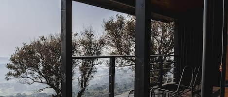 Um deck de madeira com piscina, com vista para uma paisagem deslumbrante.