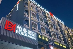 Um hotel com vários andares, varandas e placas indicando que se trata de um hotel Bormann.