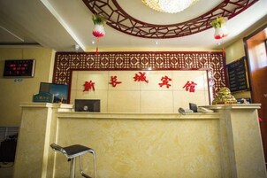 Uma mesa de recepção com design tradicional chinês, um computador e um telefone.