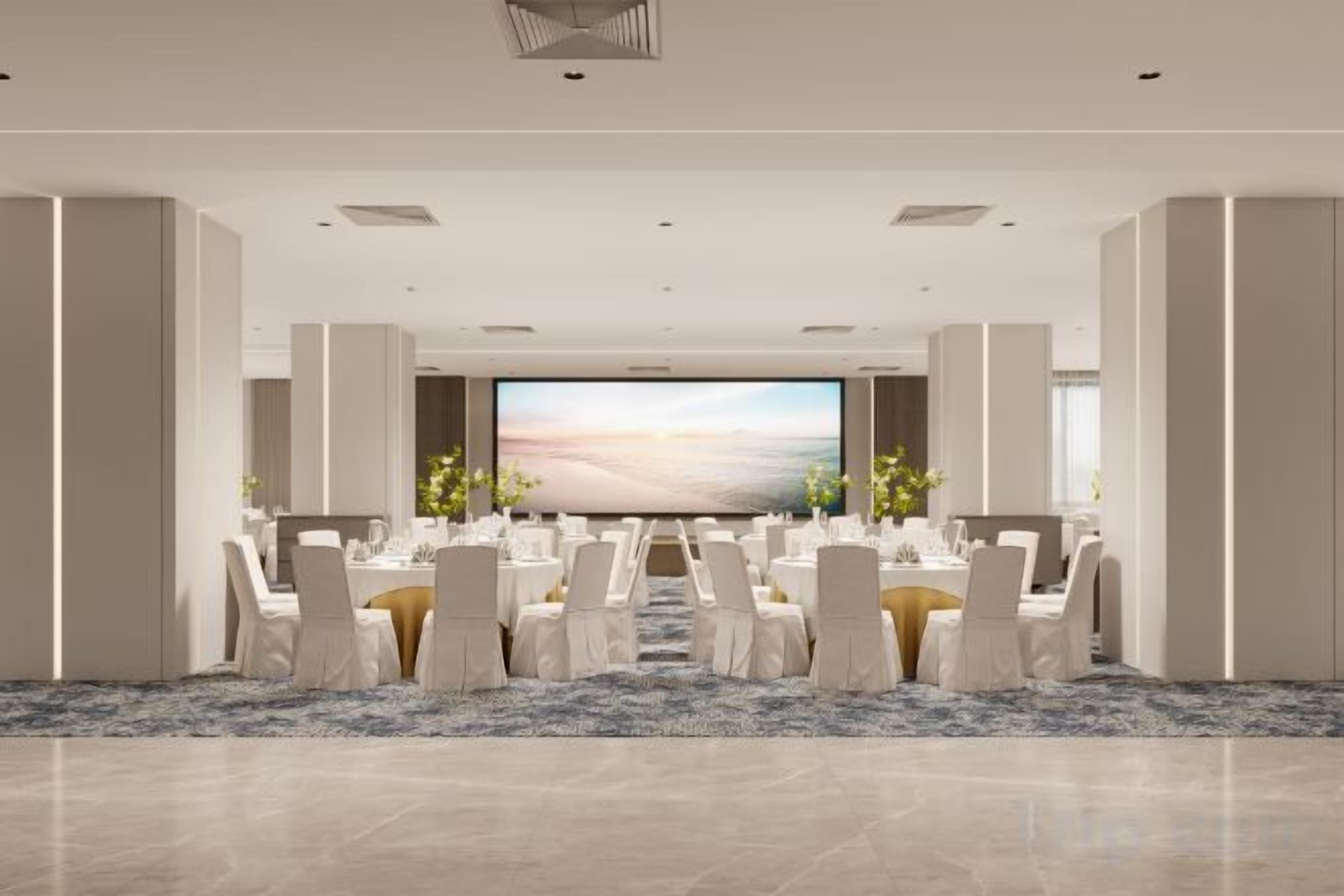 Uma sala de conferências com uma tela grande, mesas redondas e cadeiras dispostas para uma reunião.